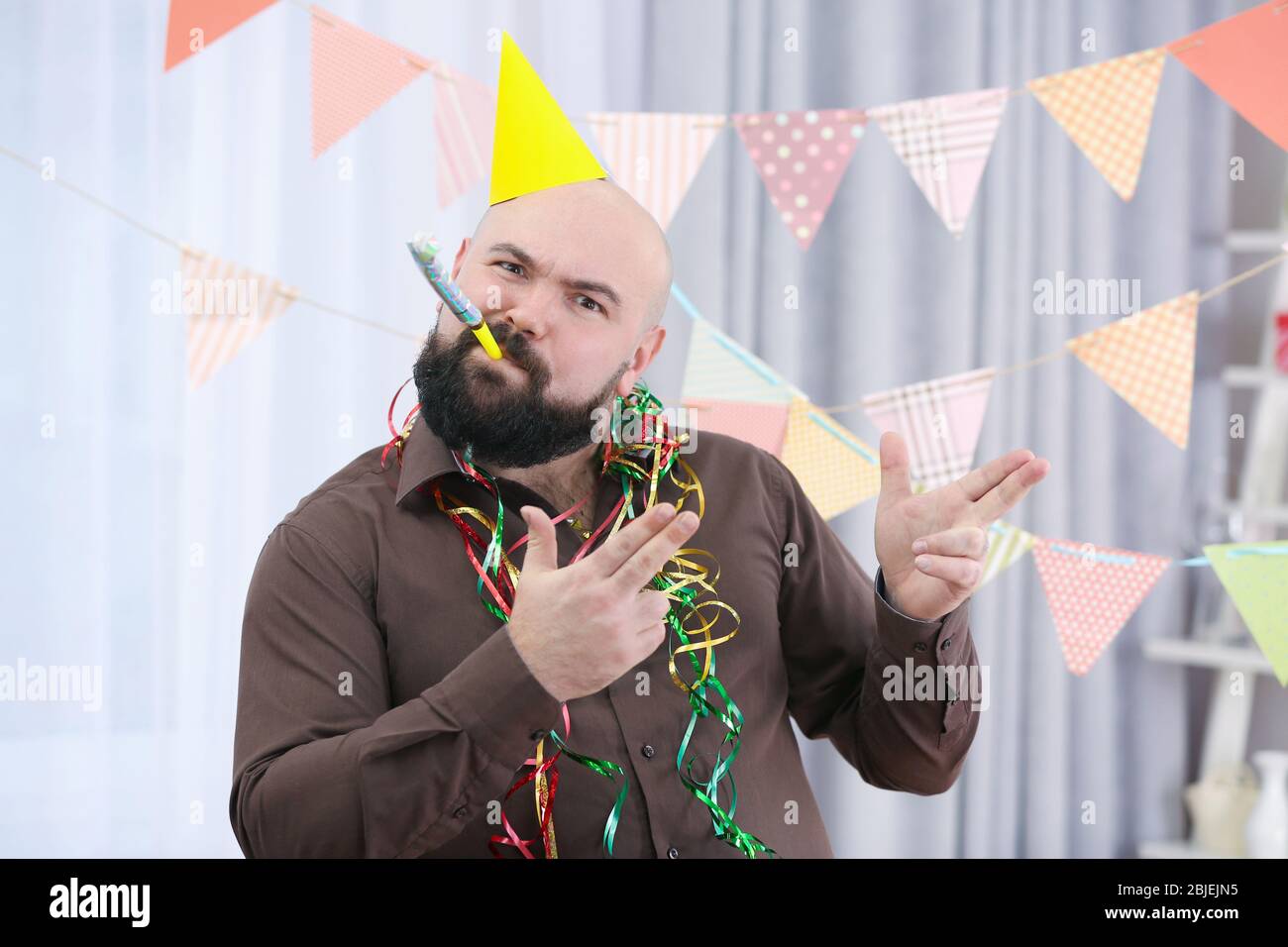 Funny fat man celebrating birthday at home Stock Photo - Alamy