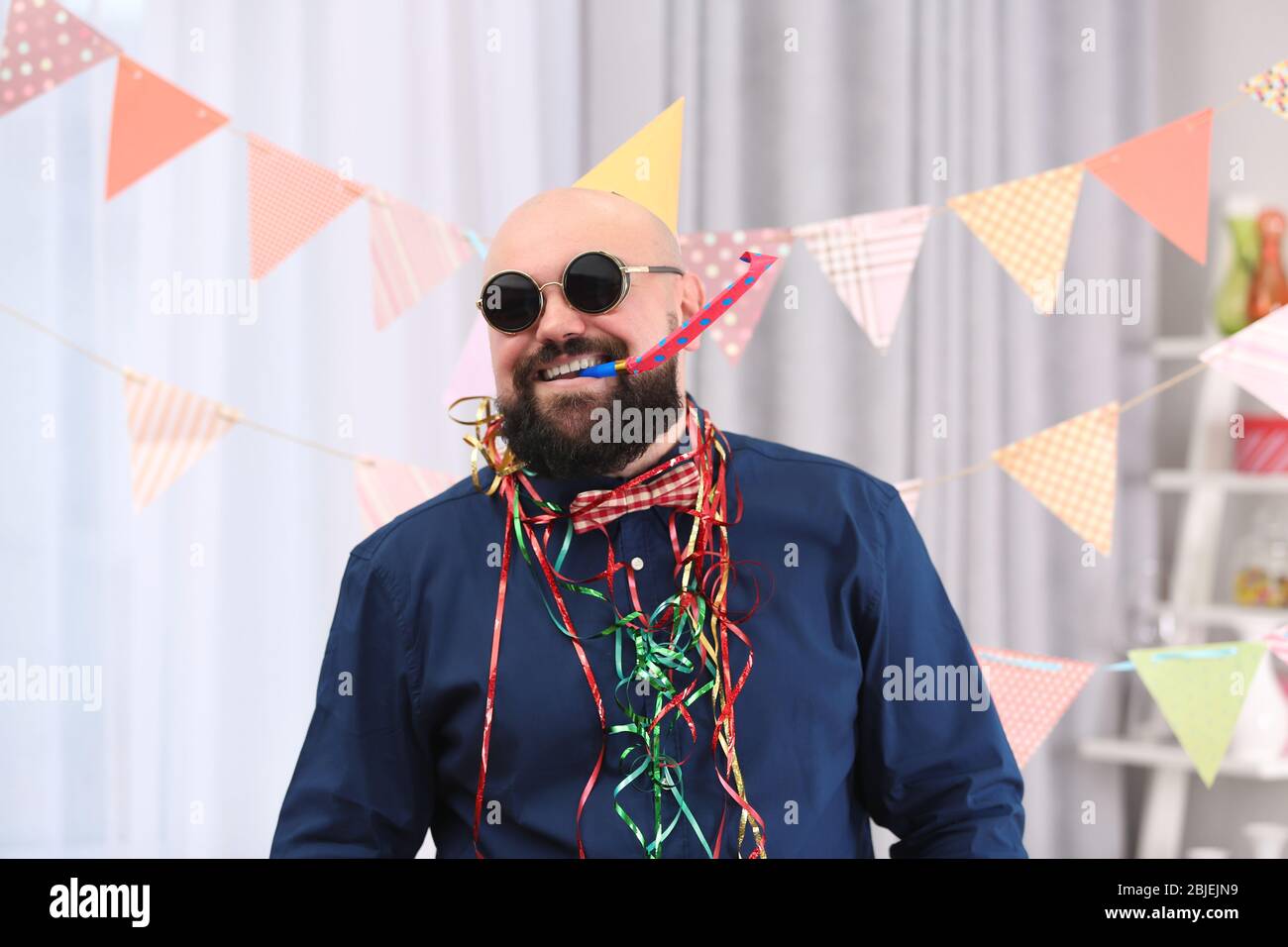 Funny fat man celebrating birthday at home Stock Photo - Alamy