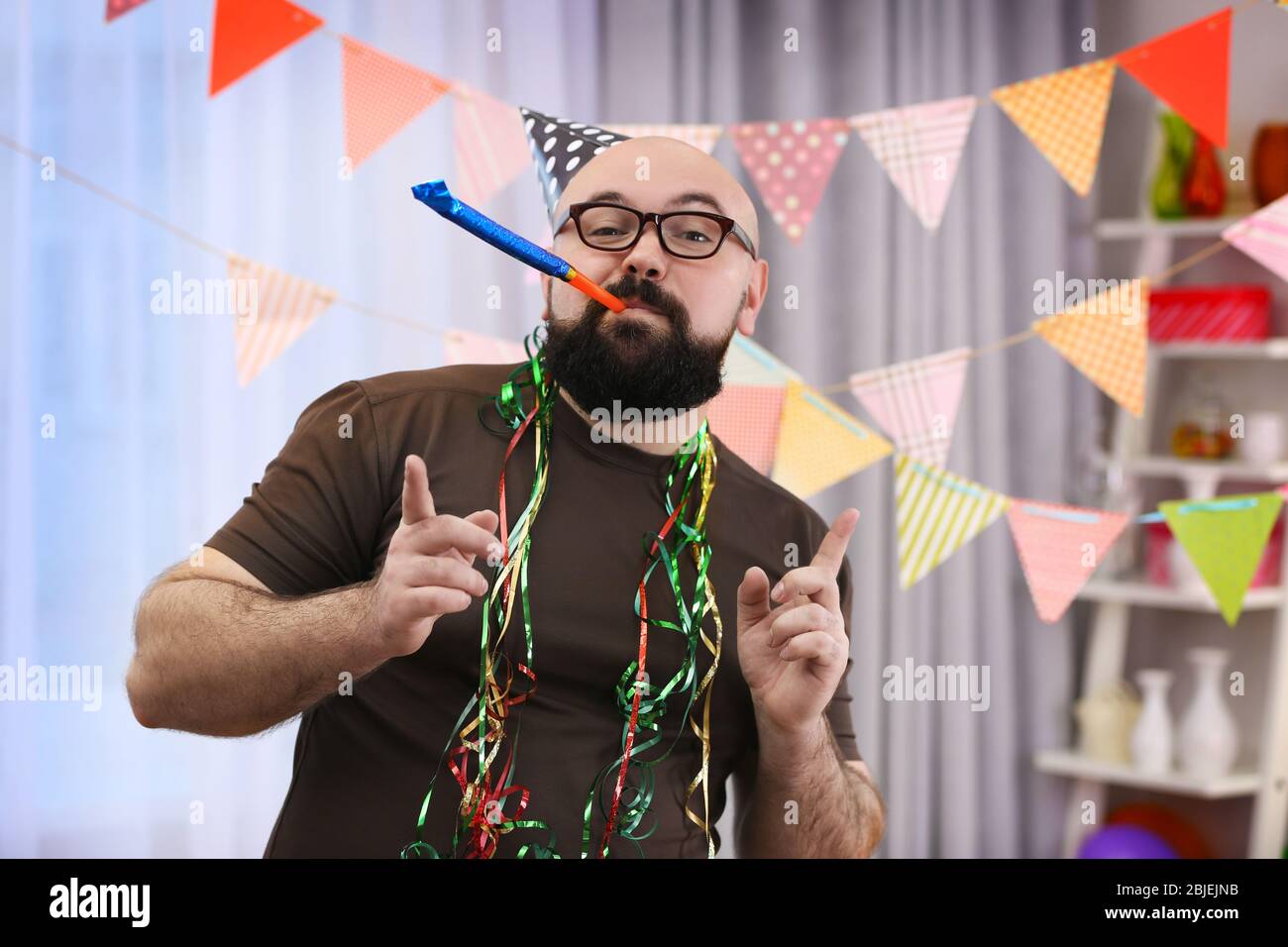 Funny fat man celebrating birthday at home Stock Photo - Alamy