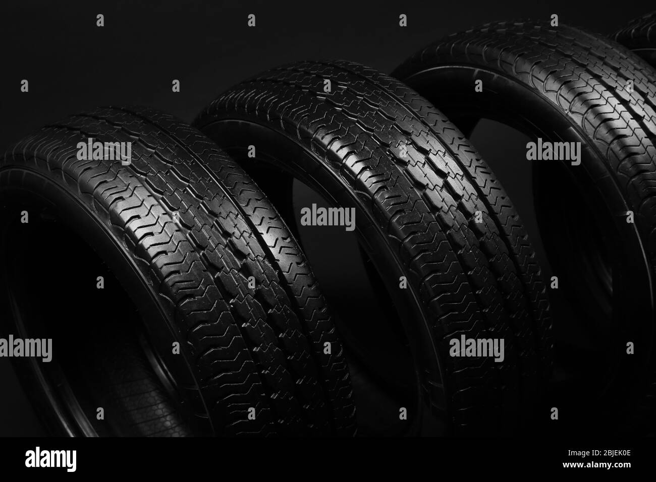 Modern car tires on dark background, closeup Stock Photo - Alamy