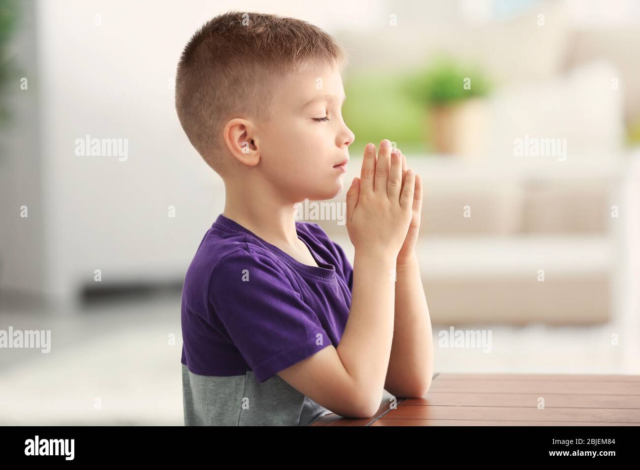 Cute little boy praying at home Stock Photo - Alamy