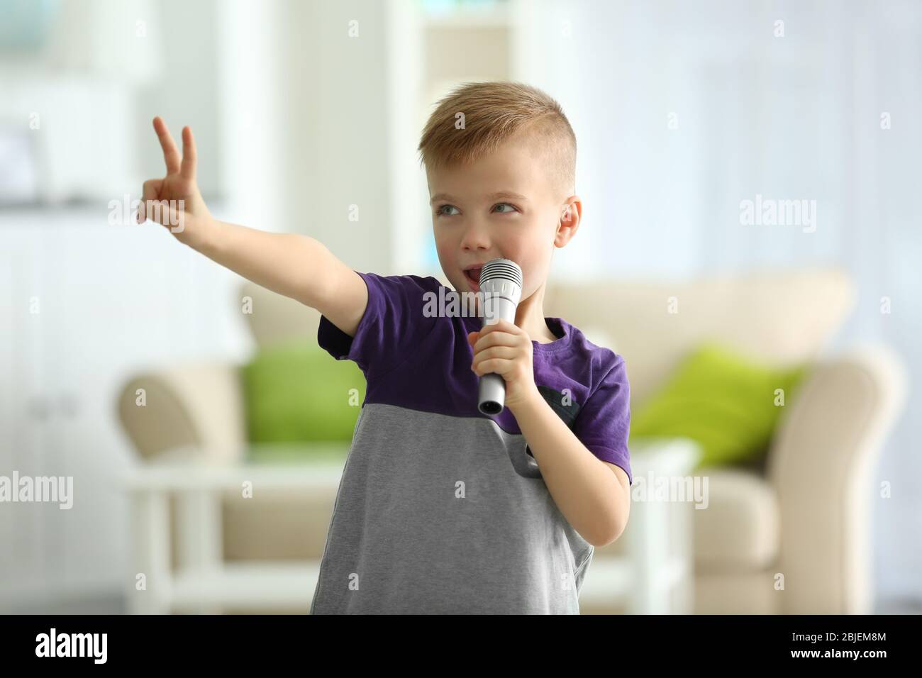 Cute little boy with microphone at home Stock Photo - Alamy