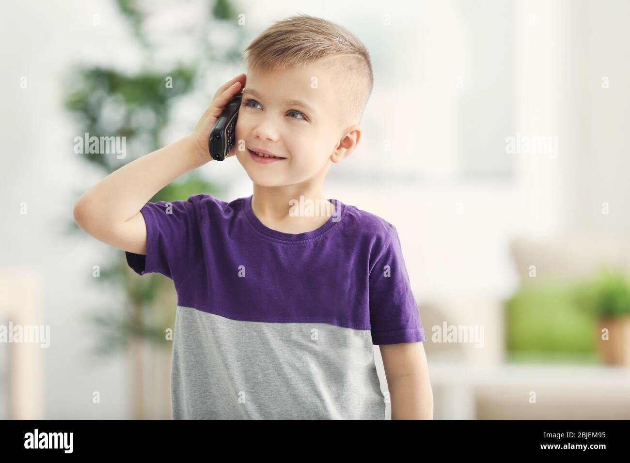 Cute little boy talking by telephone at home Stock Photo - Alamy