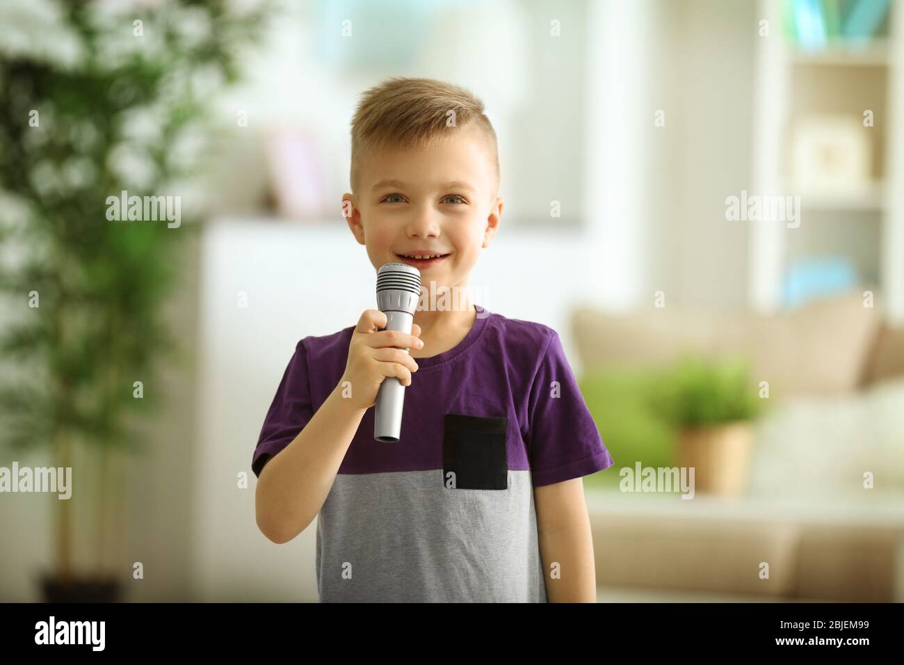 Cute little boy with microphone at home Stock Photo - Alamy