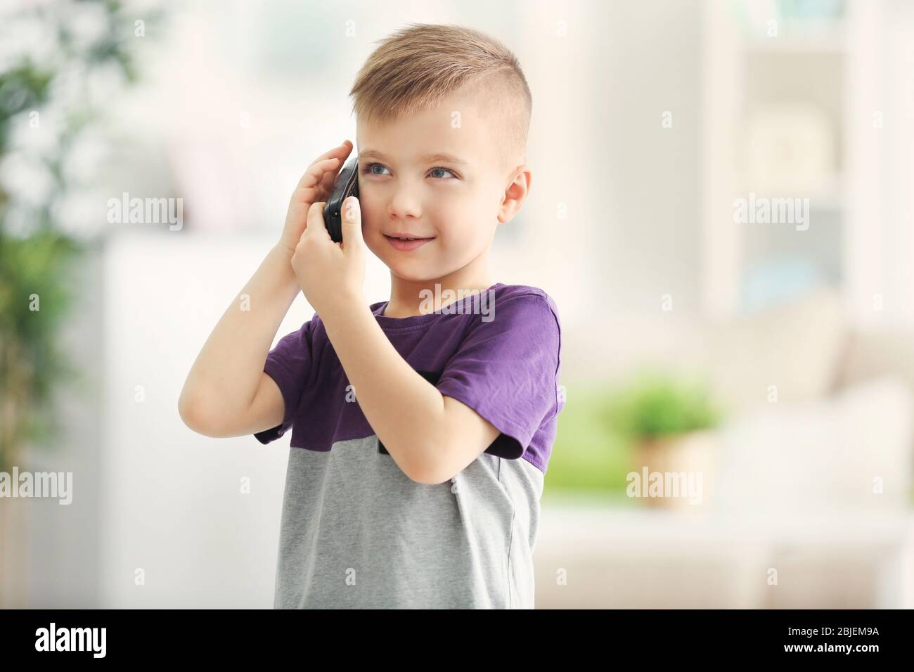 Cute little boy talking by telephone at home Stock Photo - Alamy