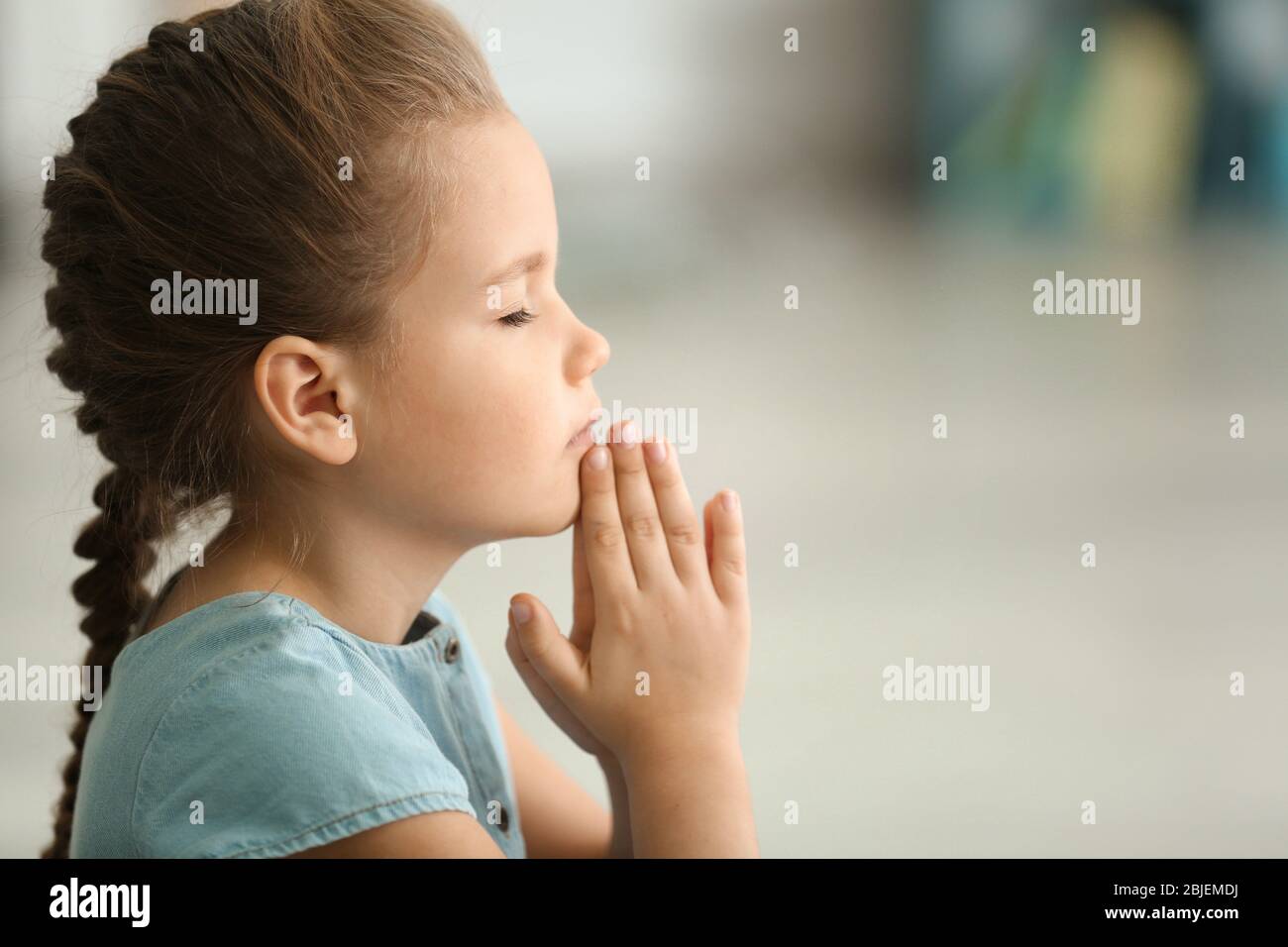 Cute little girl praying at home Stock Photo - Alamy