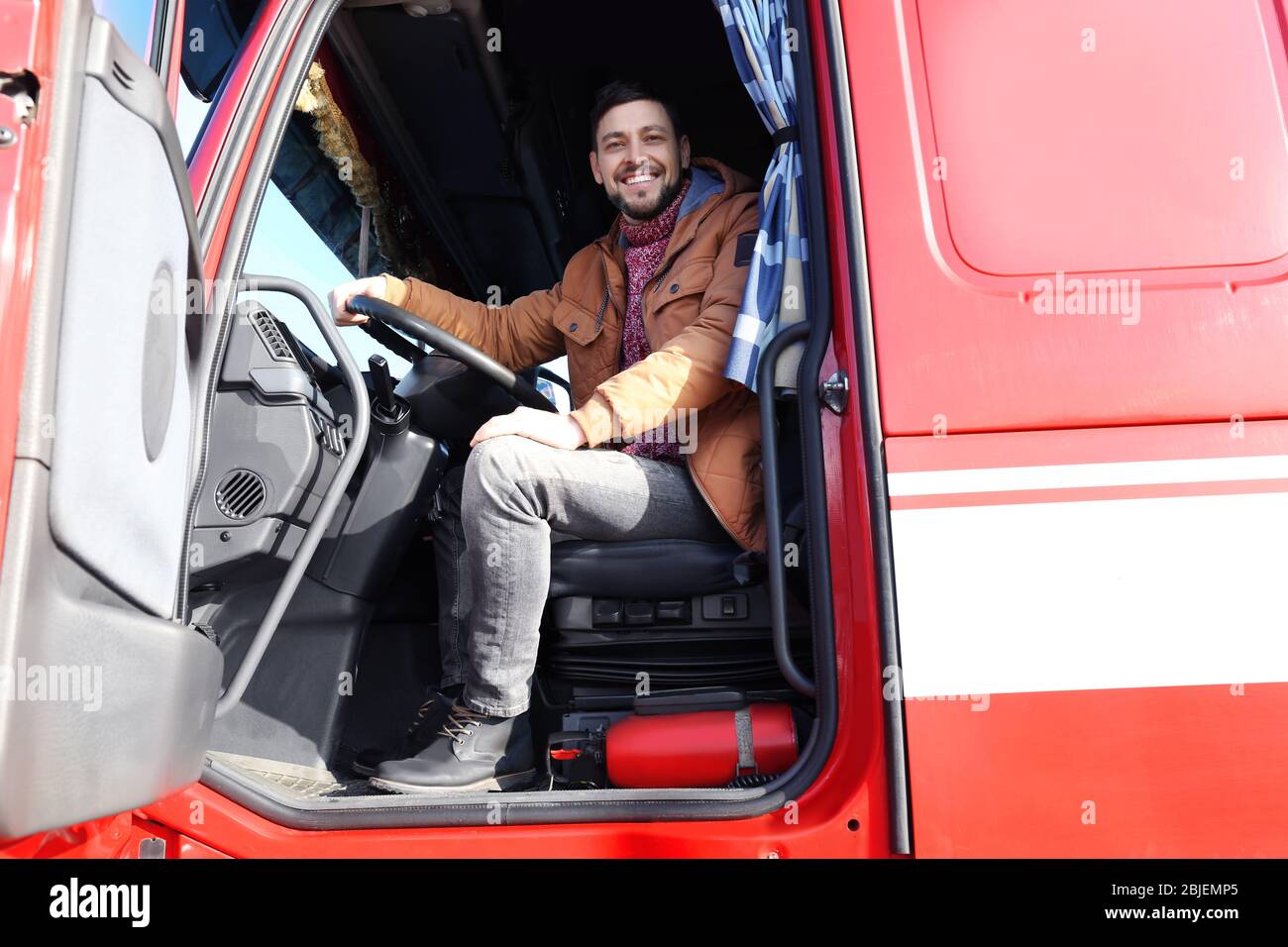 Driver in cabin of big modern truck Stock Photo - Alamy
