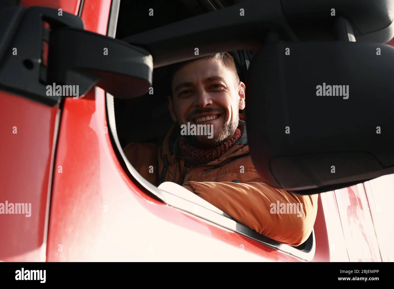 Male driver looking out of truck window Stock Photo - Alamy