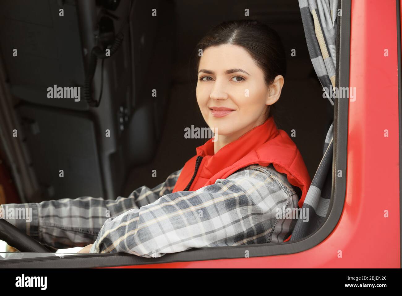 Female driver looking out of truck window Stock Photo - Alamy