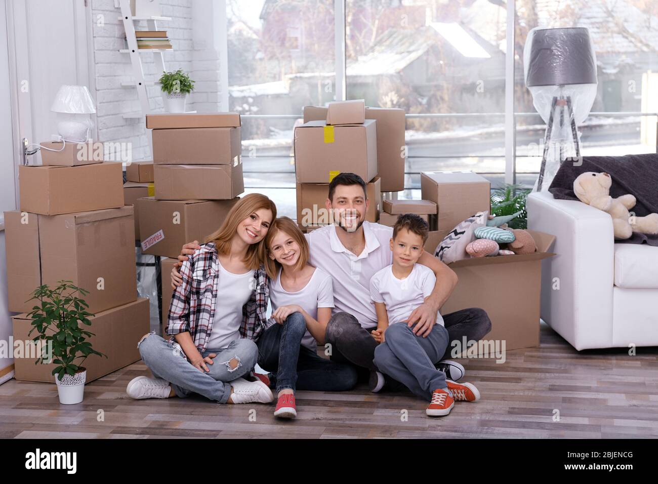 House move concept. Happy family sitting on floor in new home Stock ...