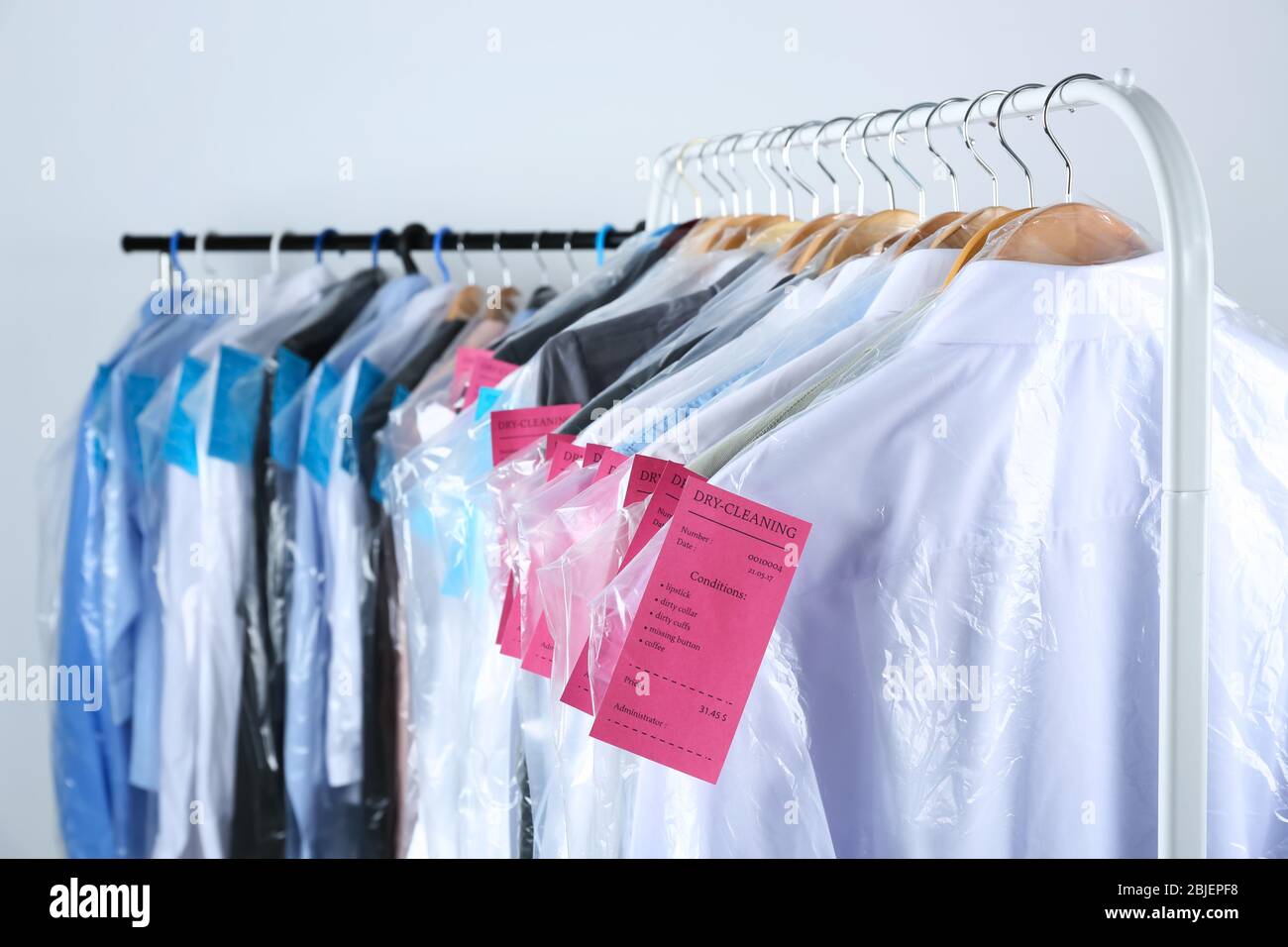 Rack of clean clothes hanging on hangers at dry-cleaning Stock Photo ...