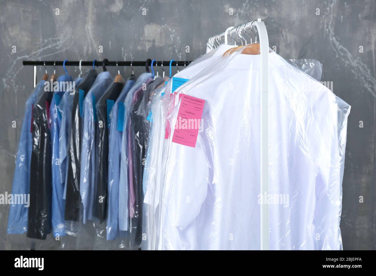 Rack of clean clothes hanging on hangers at dry-cleaning Stock Photo ...