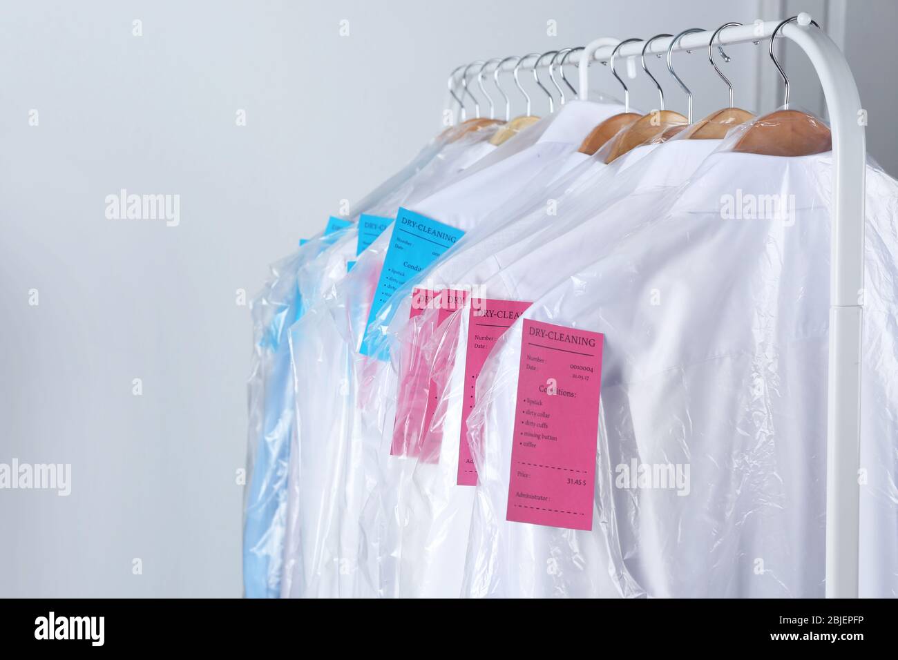 Rack of clean clothes hanging on hangers at dry-cleaning Stock Photo ...