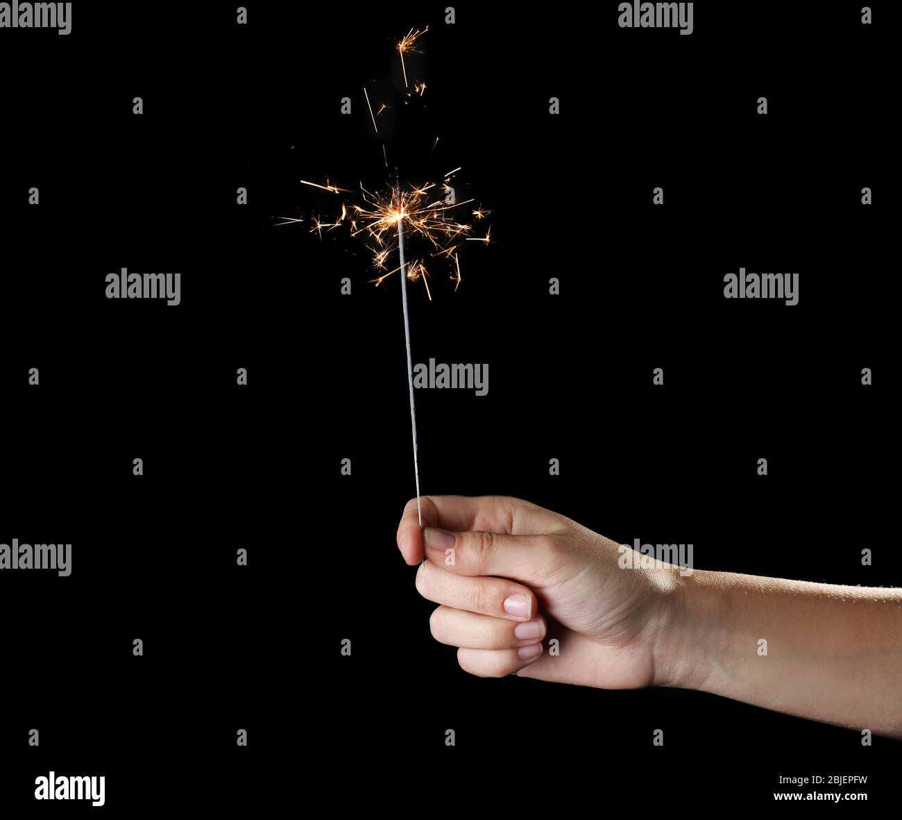 Female hand holding sparkler on dark background Stock Photo - Alamy