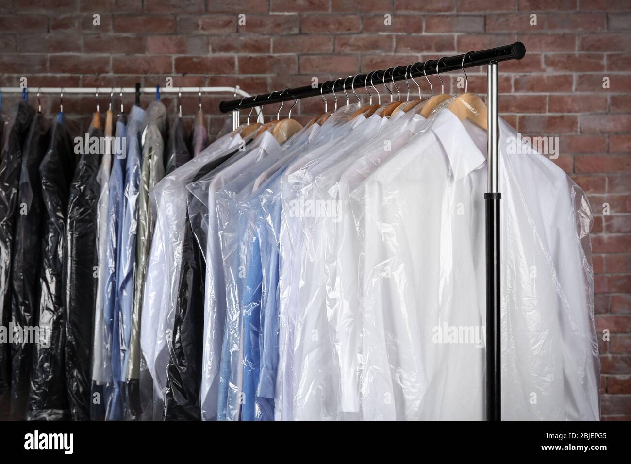 Rack of clean clothes hanging on hangers at dry-cleaning Stock Photo ...