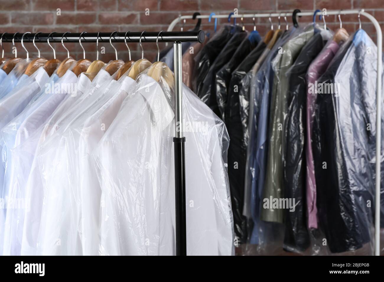 Rack of clean clothes hanging on hangers at dry-cleaning Stock Photo ...