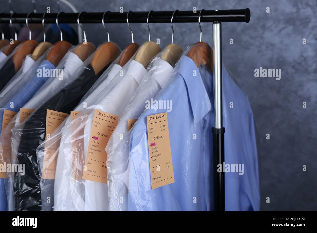 Rack of clean clothes hanging on hangers at dry-cleaning Stock Photo ...