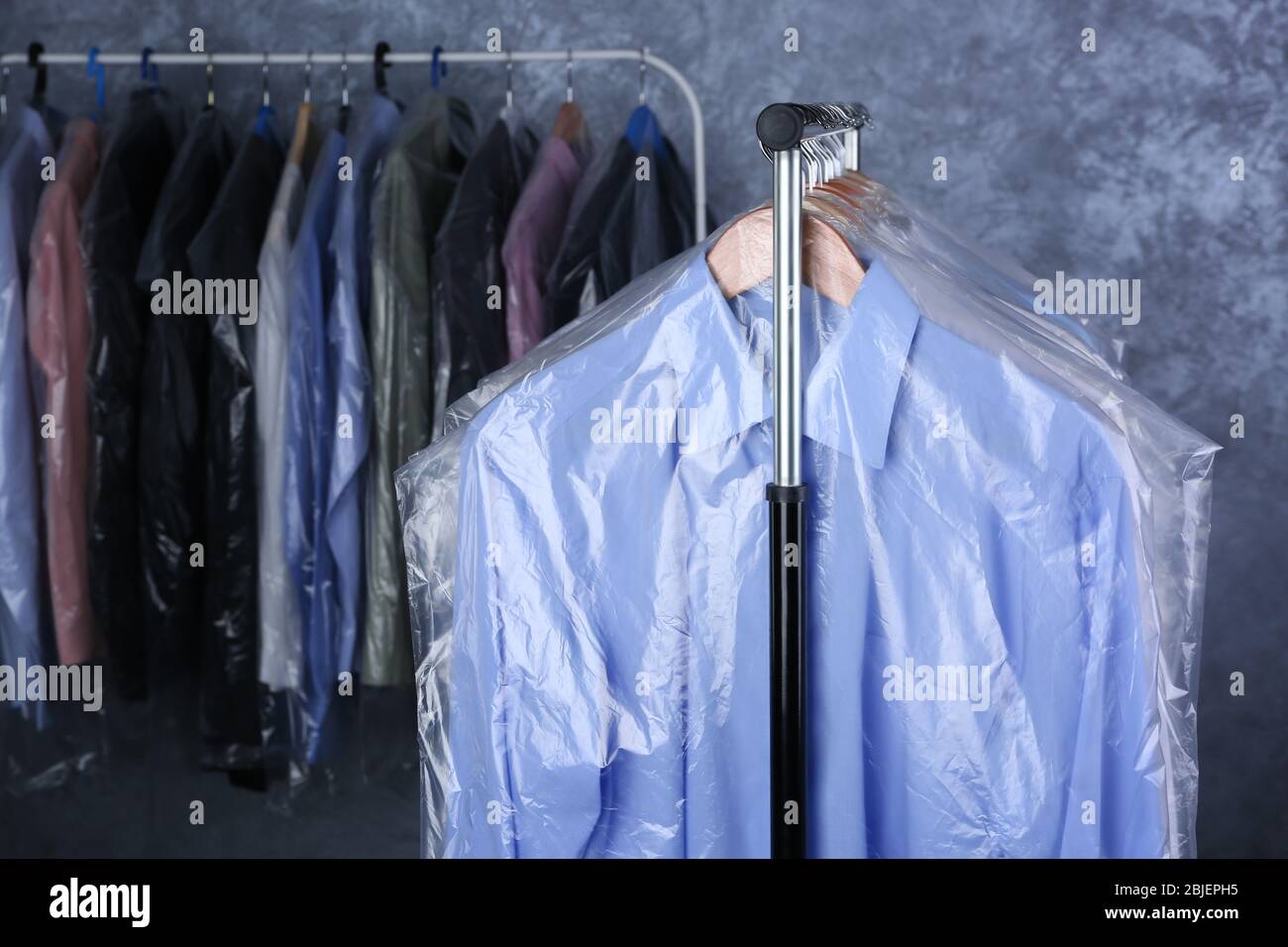 Rack of clean clothes hanging on hangers at dry-cleaning Stock Photo ...
