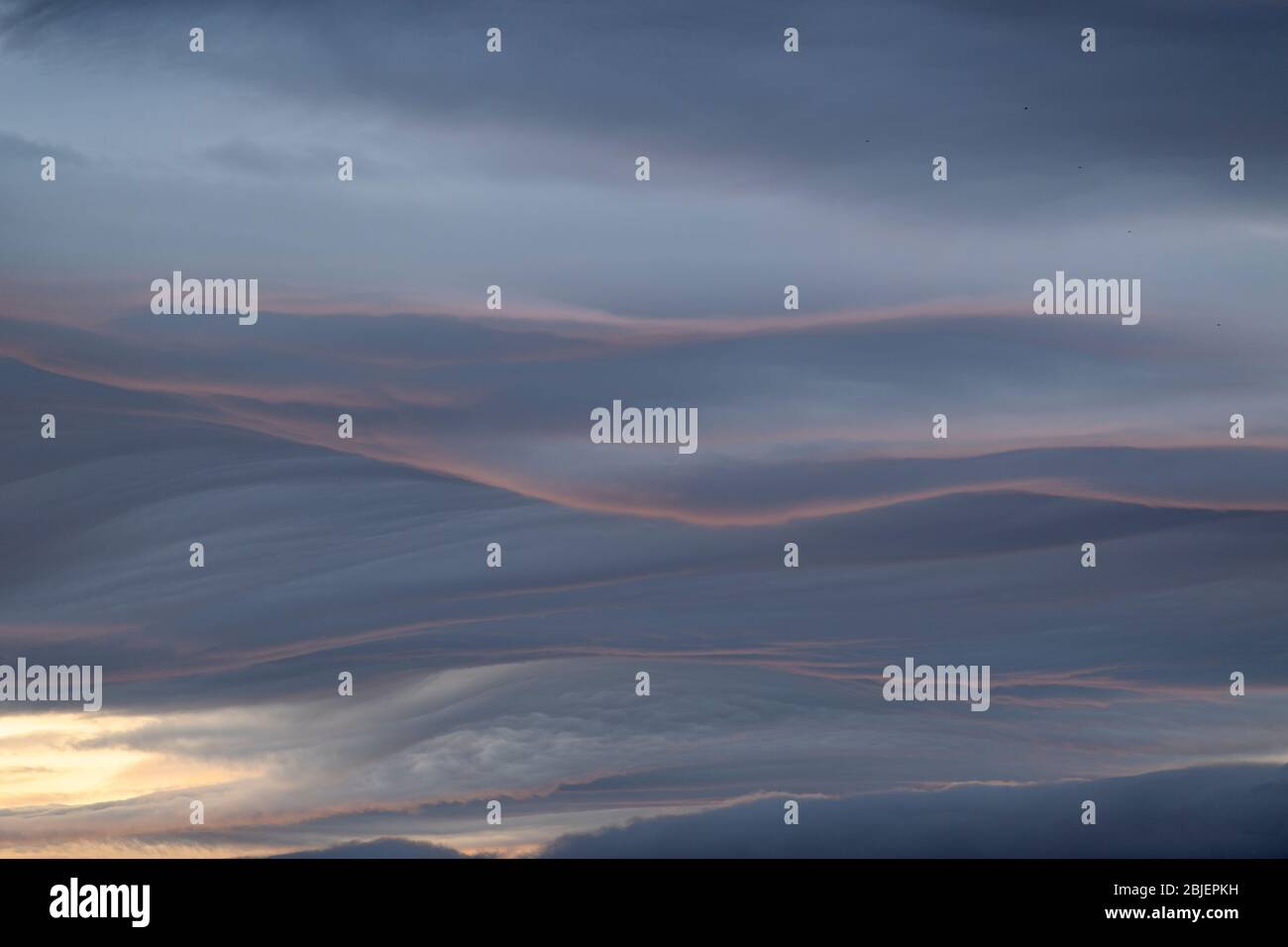 Brooding clouds catching a hint of the setting sun along their edge ...