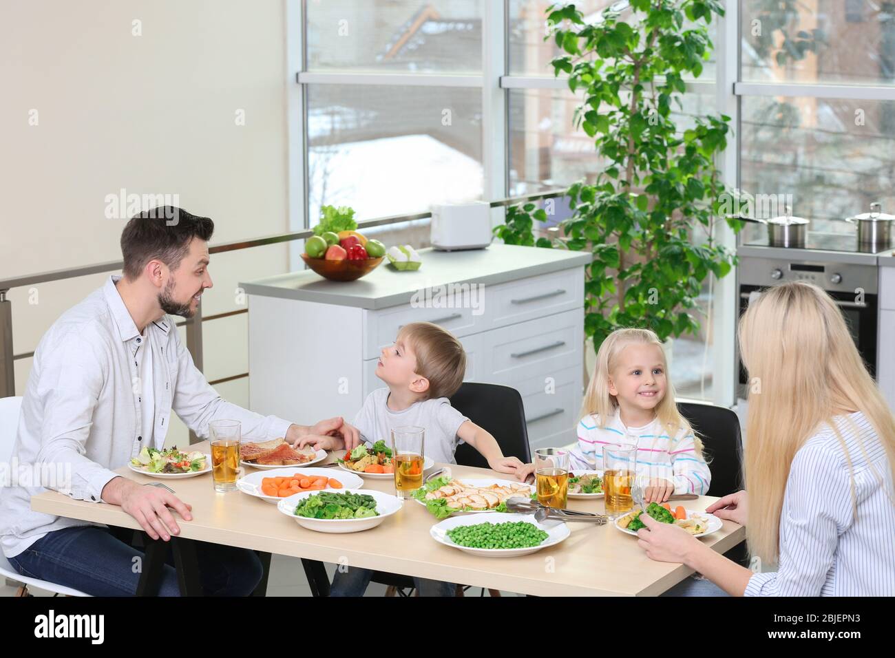 Happy family having breakfast at home Stock Photo - Alamy