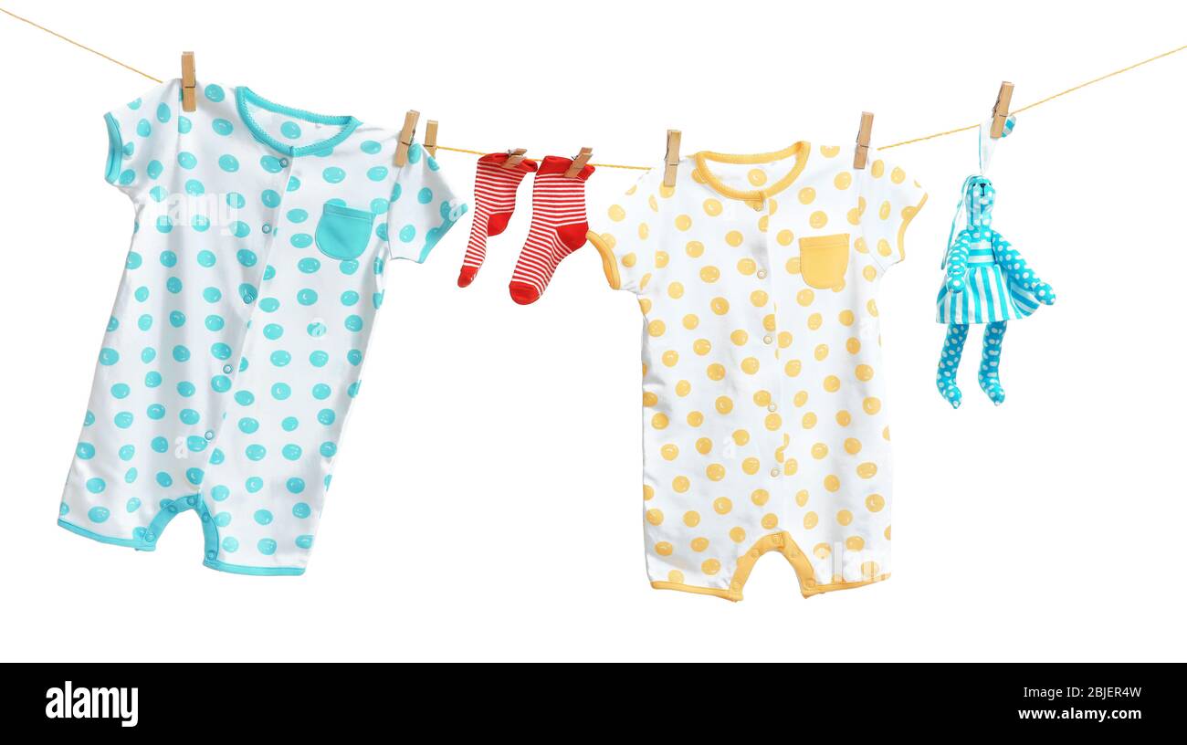 Baby clothes hanging on white background Stock Photo - Alamy
