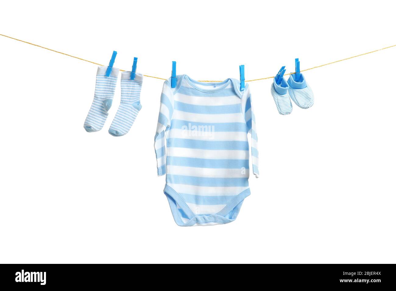 Baby clothes hanging on white background Stock Photo - Alamy