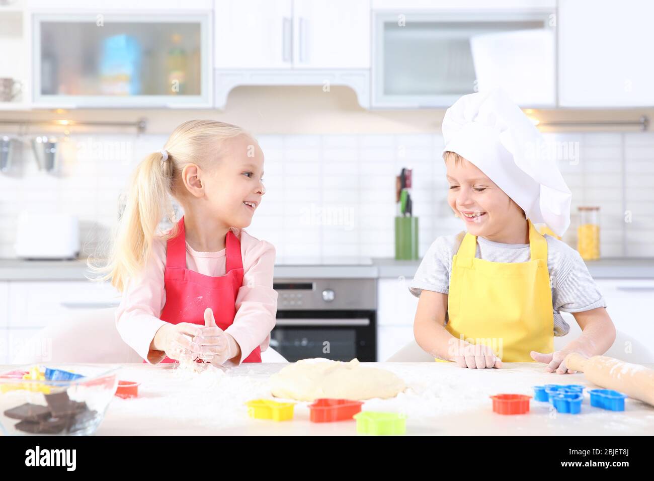 Little kids making biscuits on table Stock Photo - Alamy