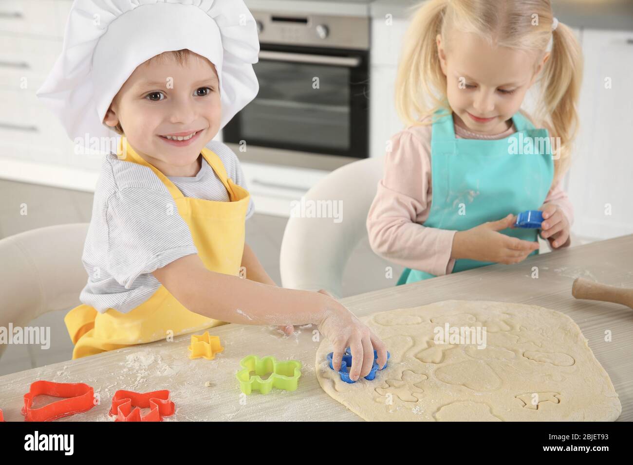 Little kids making biscuits on table Stock Photo - Alamy