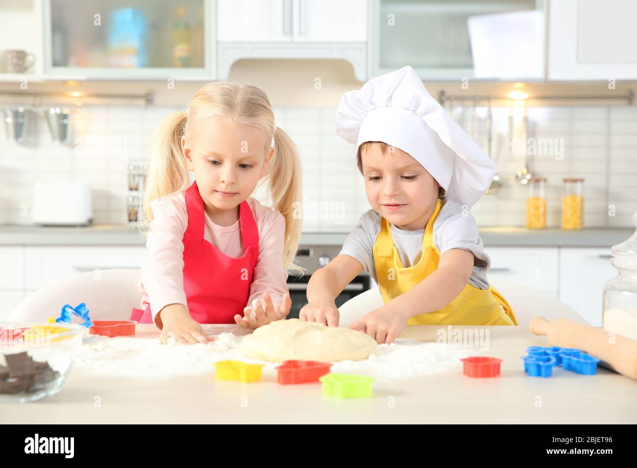 Little kids making biscuits on table Stock Photo - Alamy