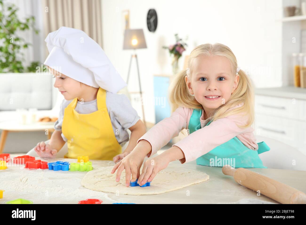 Little kids making biscuits on table Stock Photo - Alamy