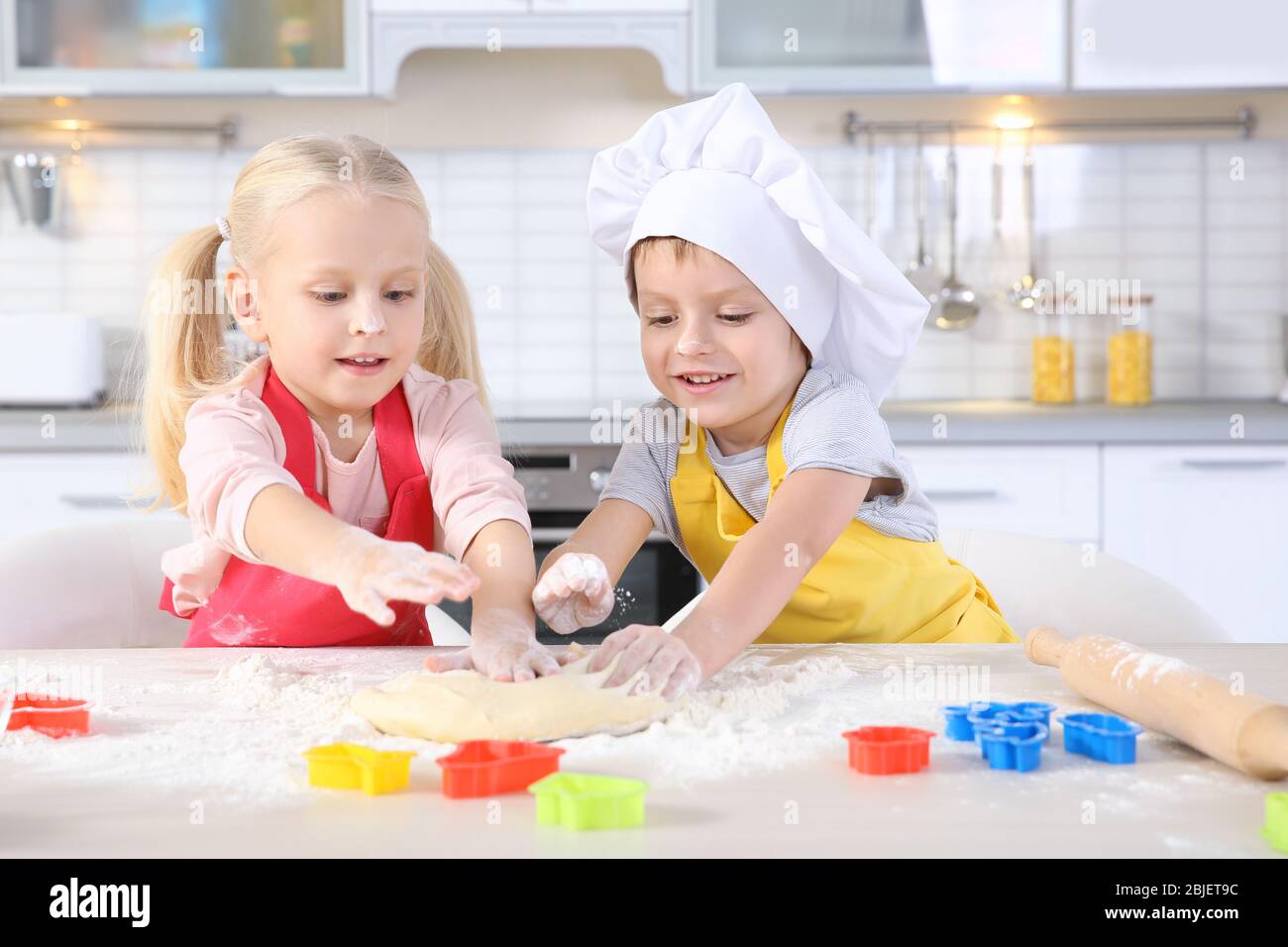 Little kids making biscuits on table Stock Photo - Alamy