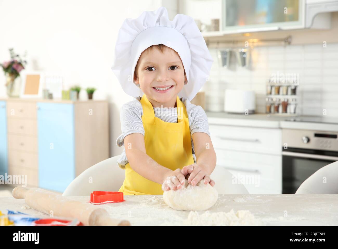 Little boy making biscuits on table Stock Photo - Alamy