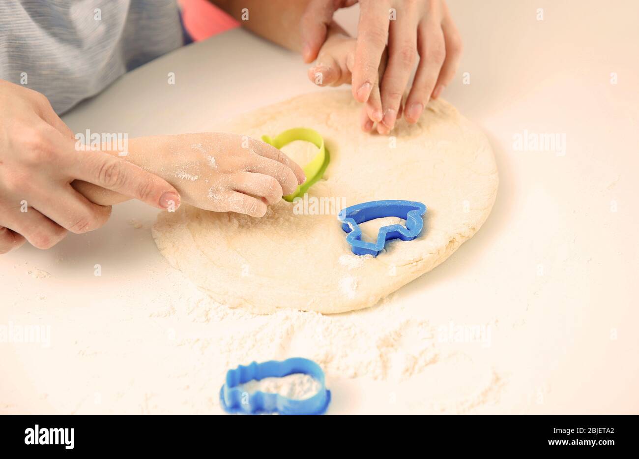 Young mother with son making biscuits on table Stock Photo - Alamy