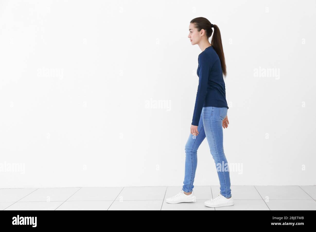 Posture concept. Young woman on white wall background Stock Photo - Alamy