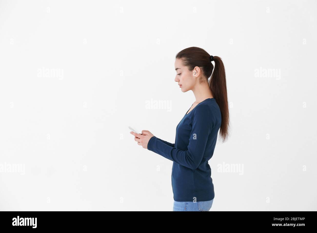 Posture concept. Young woman using smartphone against white background ...