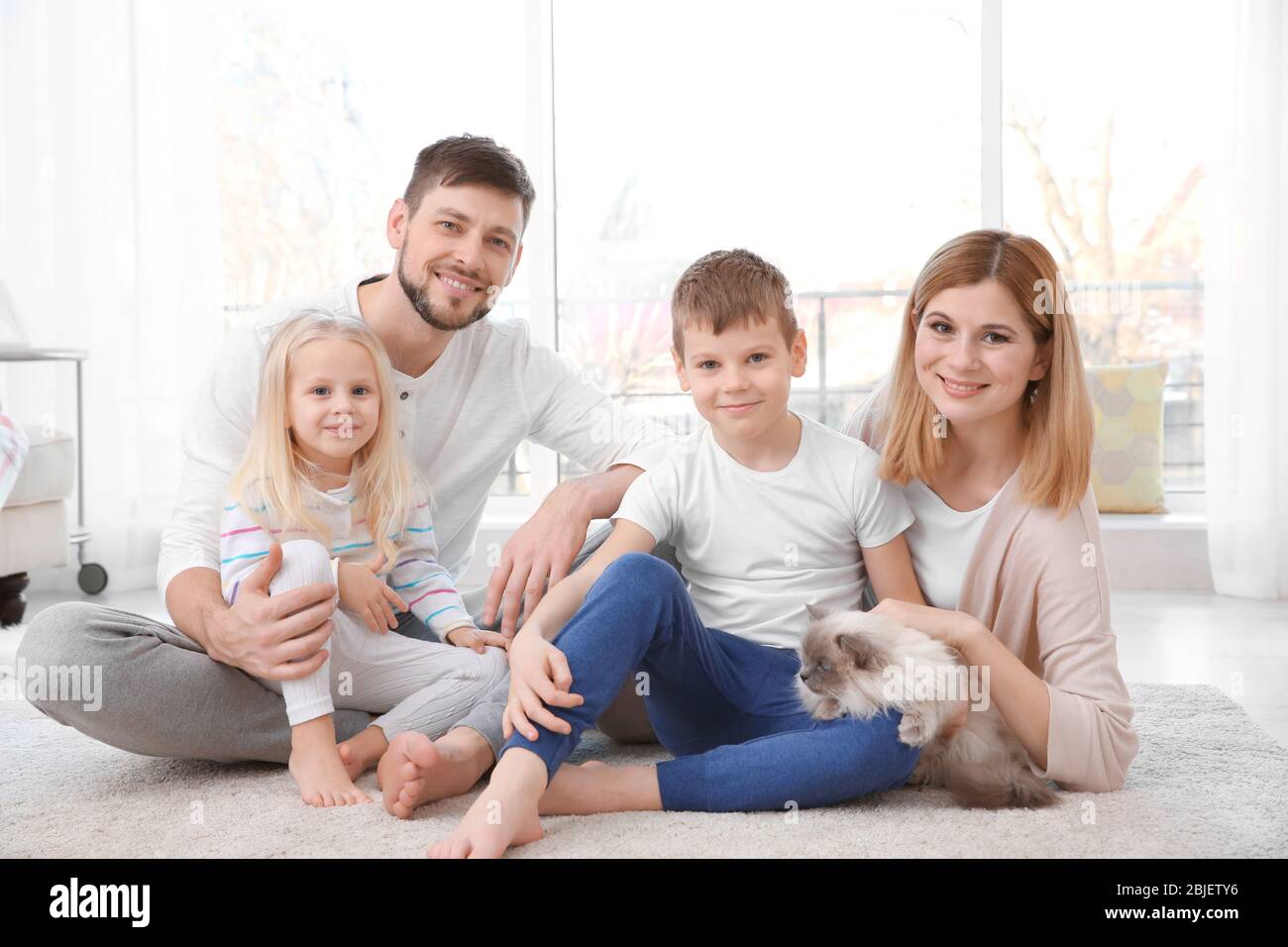 Parents with children and cat at home Stock Photo - Alamy