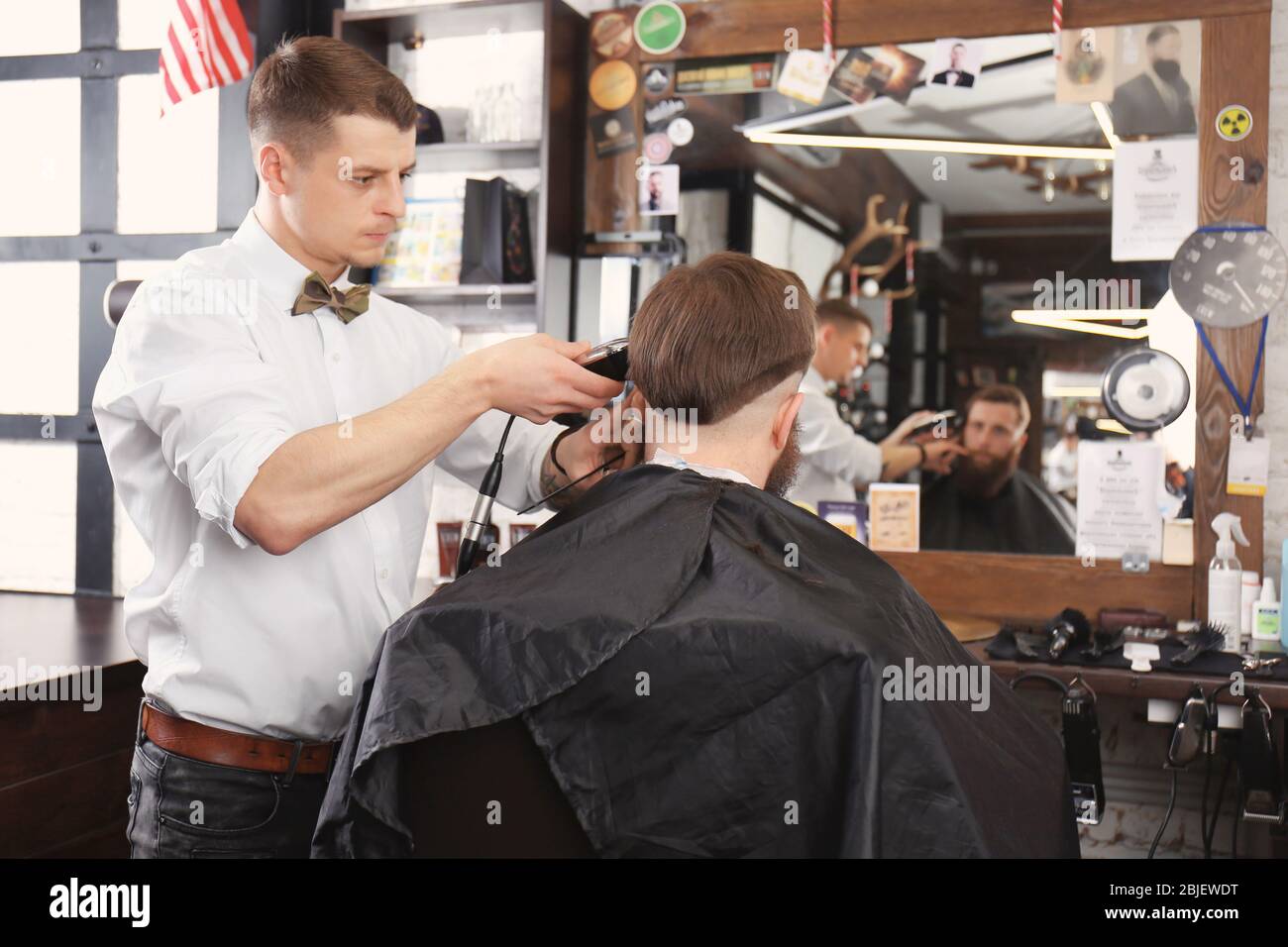 Barber making modern male hairstyle Stock Photo - Alamy