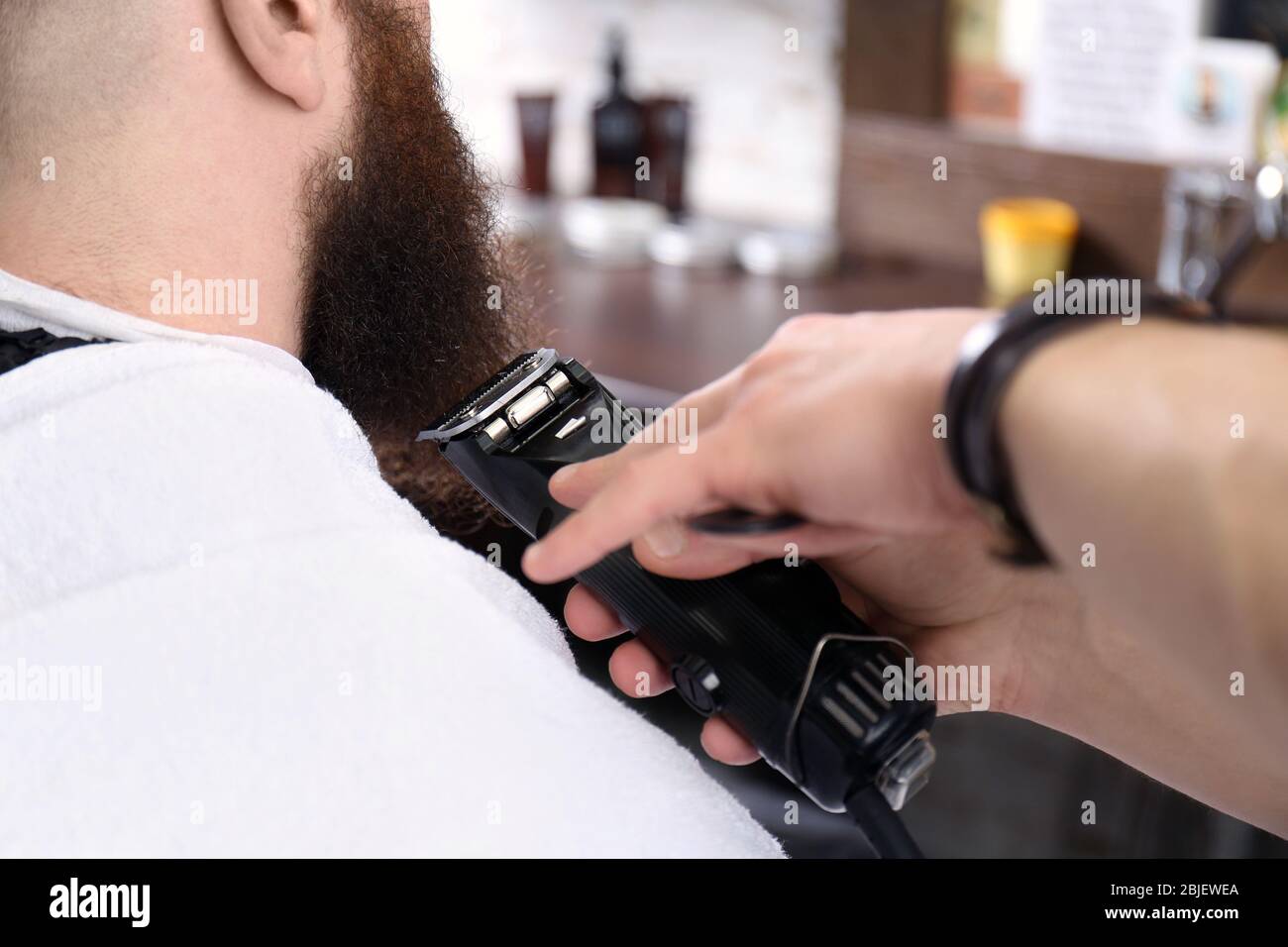 Hairdresser shaving client in barbershop Stock Photo - Alamy