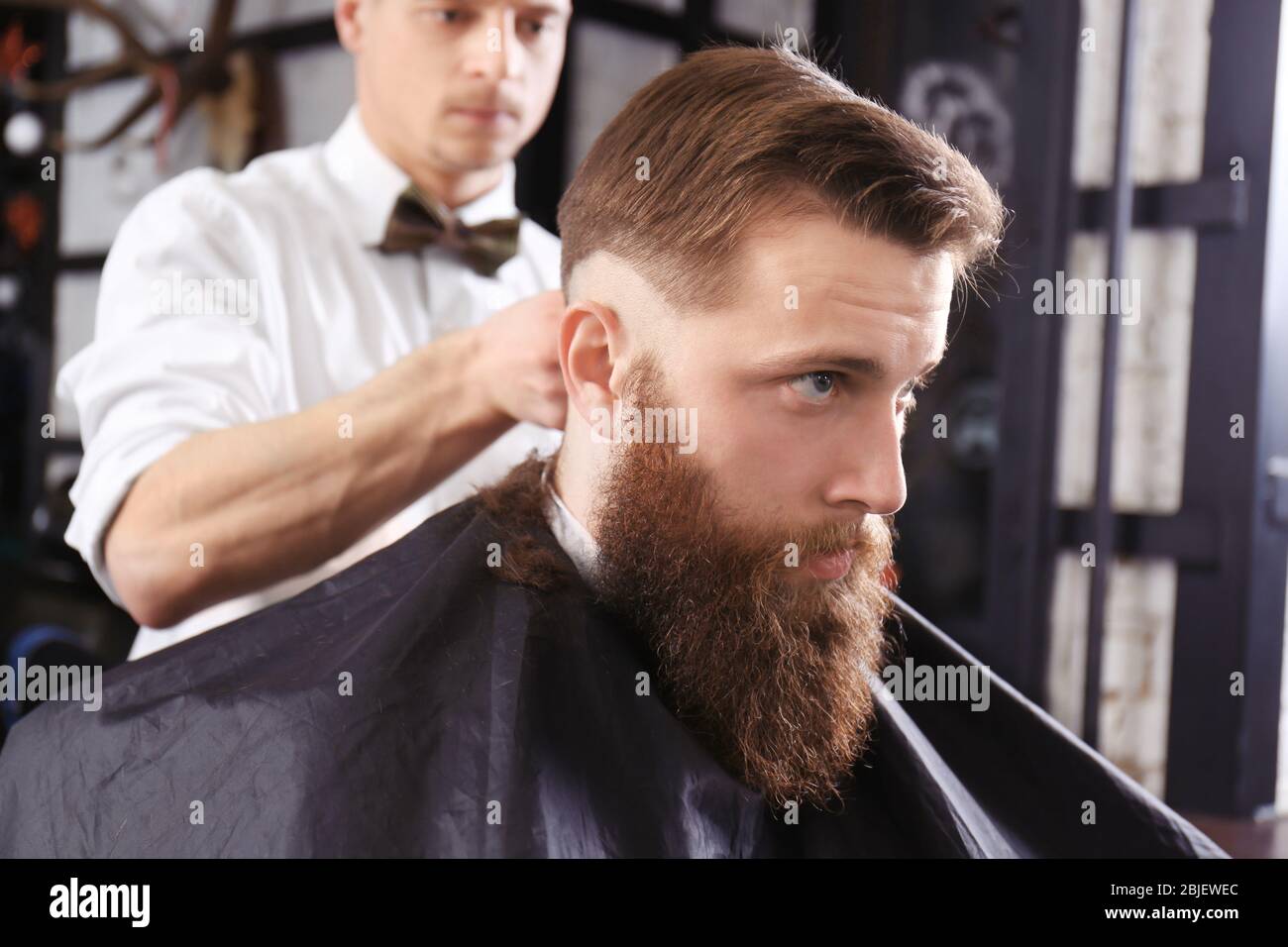 Barber making modern male hairstyle Stock Photo - Alamy