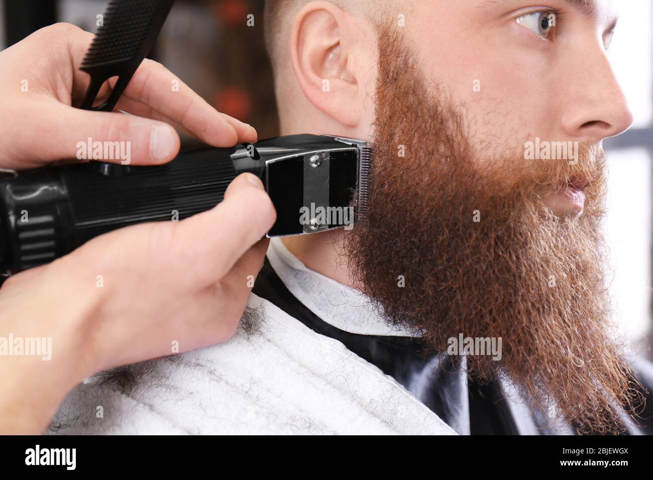 Hairdresser shaving client in barbershop Stock Photo - Alamy
