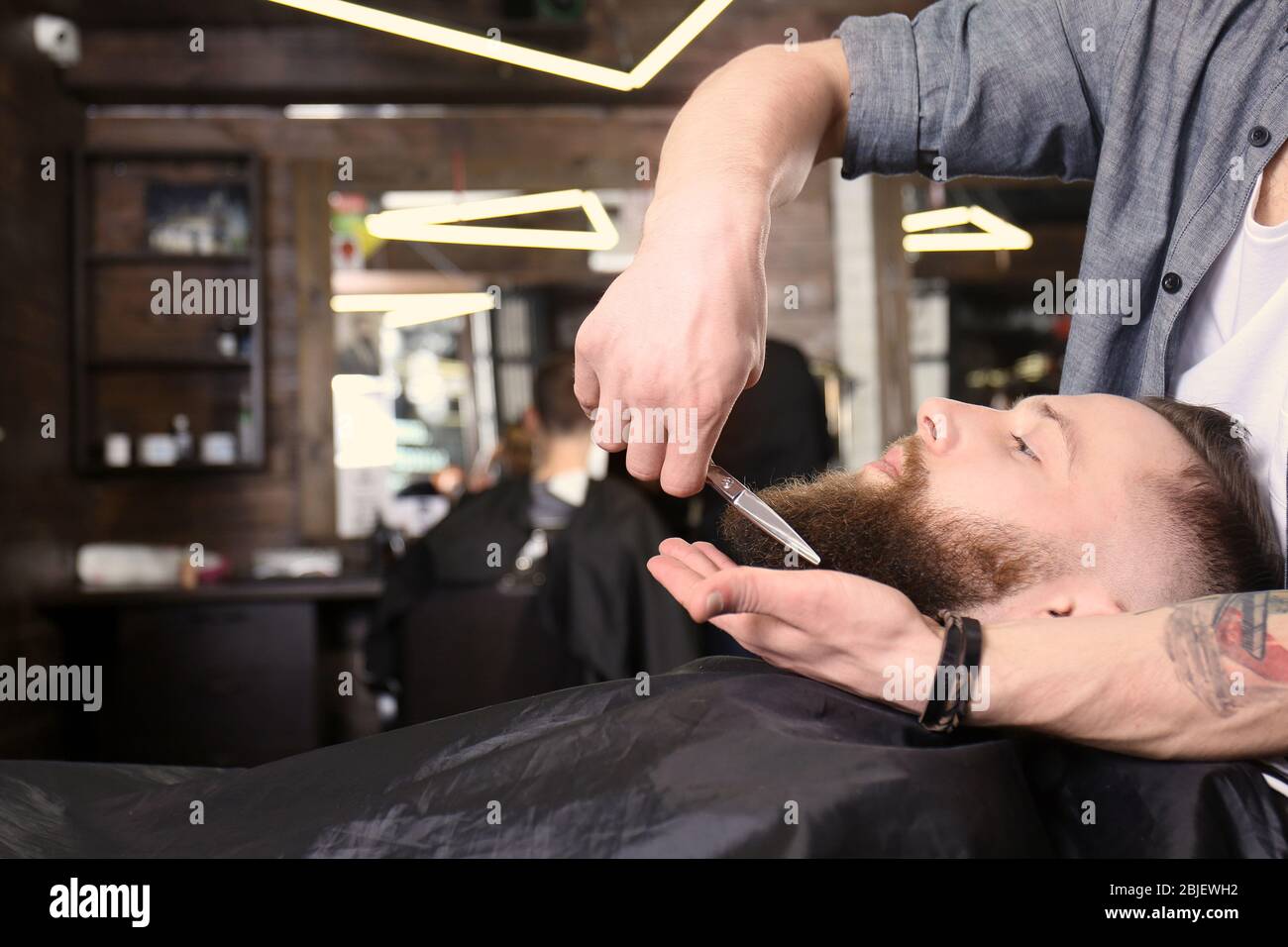 Hairdresser shaving client in barbershop Stock Photo - Alamy