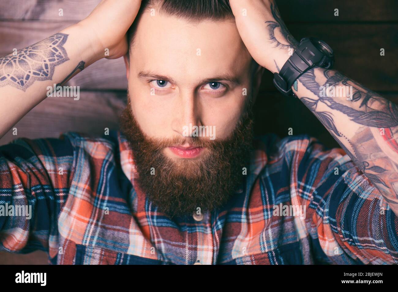 Bearded man posing on wooden background Stock Photo - Alamy