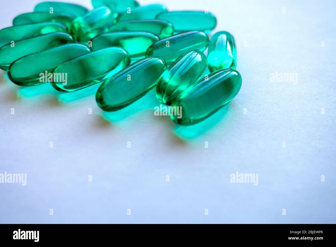 Teal blue gel caps on a white surface Stock Photo - Alamy