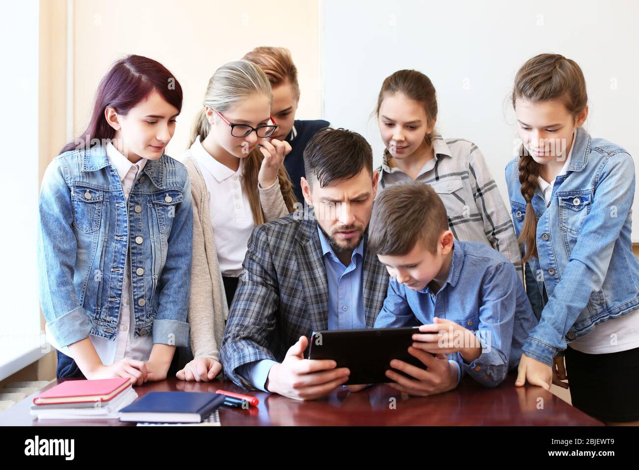 Pupils and teacher in classroom working with tablet computer Stock ...