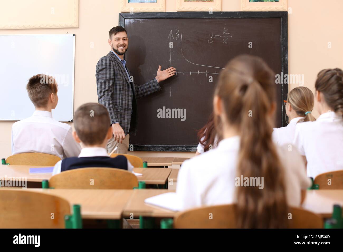 Pupils listening teacher in classroom Stock Photo - Alamy
