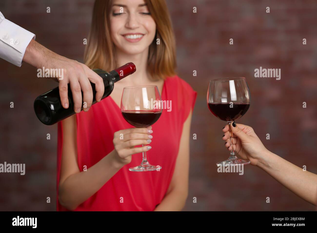 Waiter serving wine to beautiful woman at party Stock Photo - Alamy