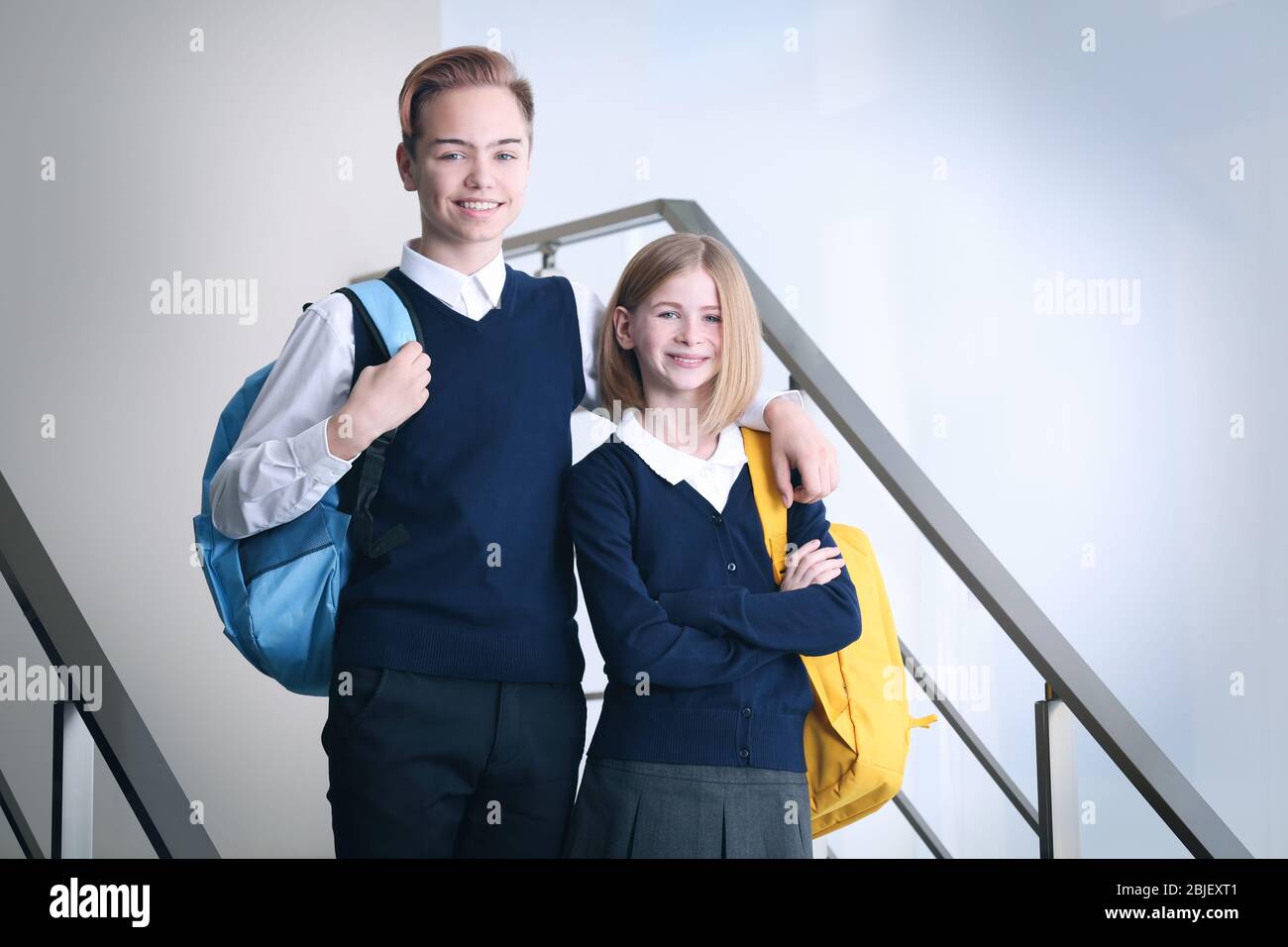 Cute boy and girl in school uniform standing on stairs Stock Photo - Alamy