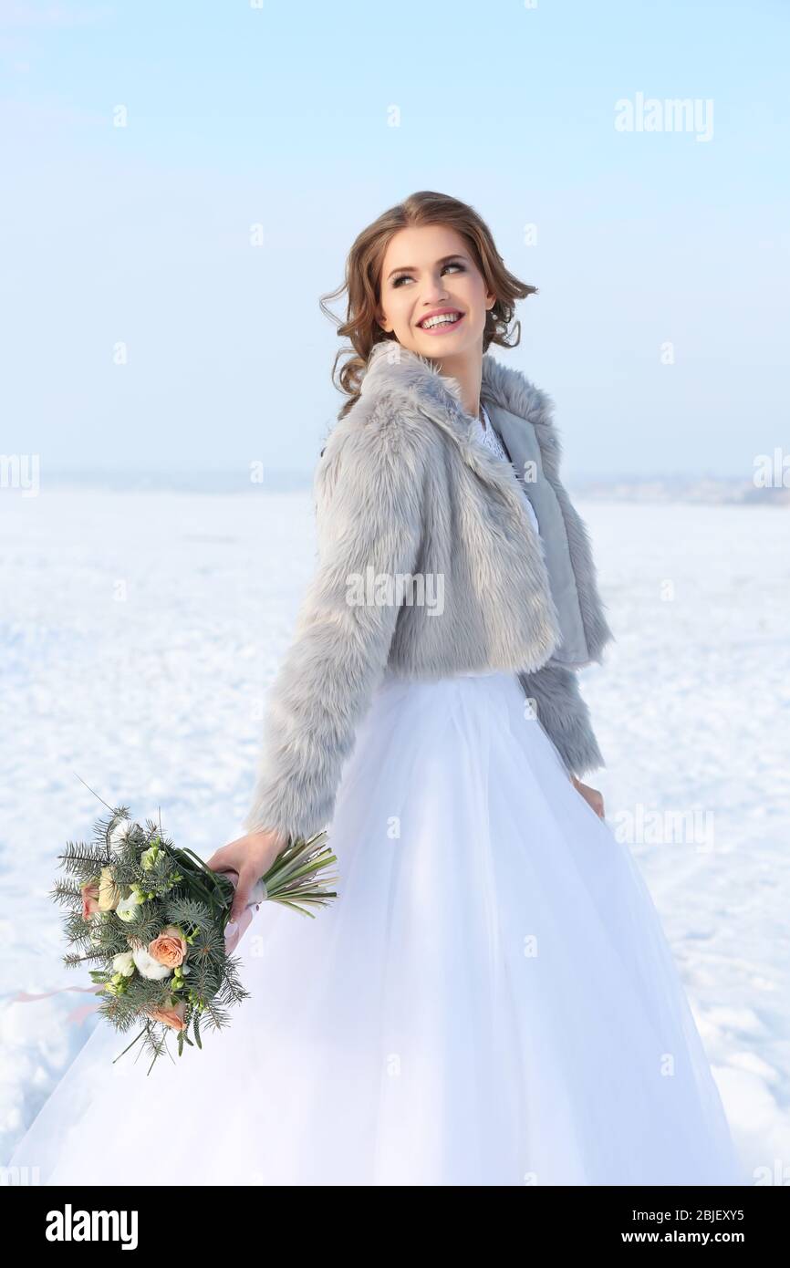 Beautiful bride with bouquet outdoors on winter day Stock Photo - Alamy