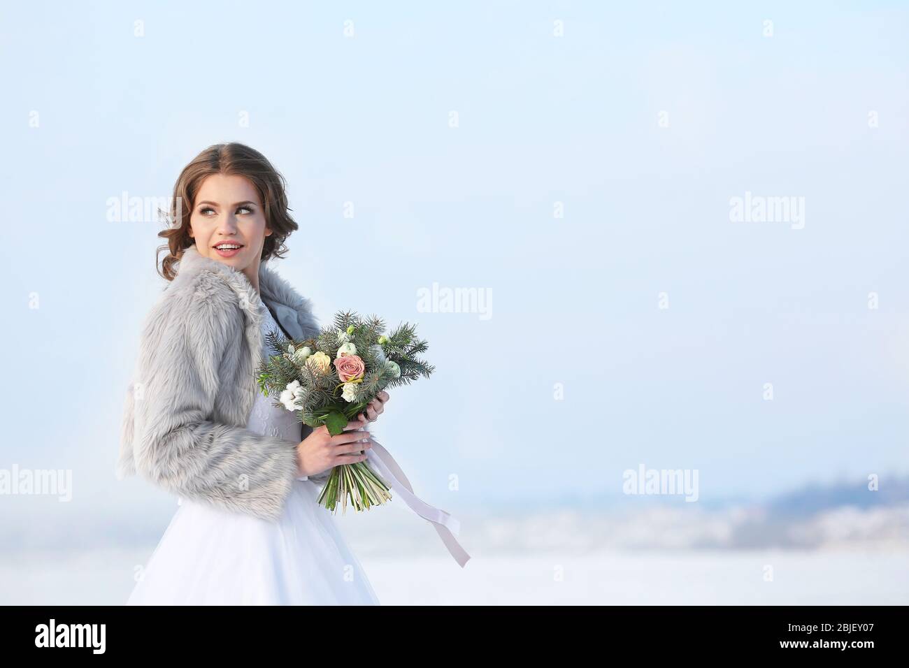 Beautiful bride with bouquet outdoors on winter day Stock Photo - Alamy