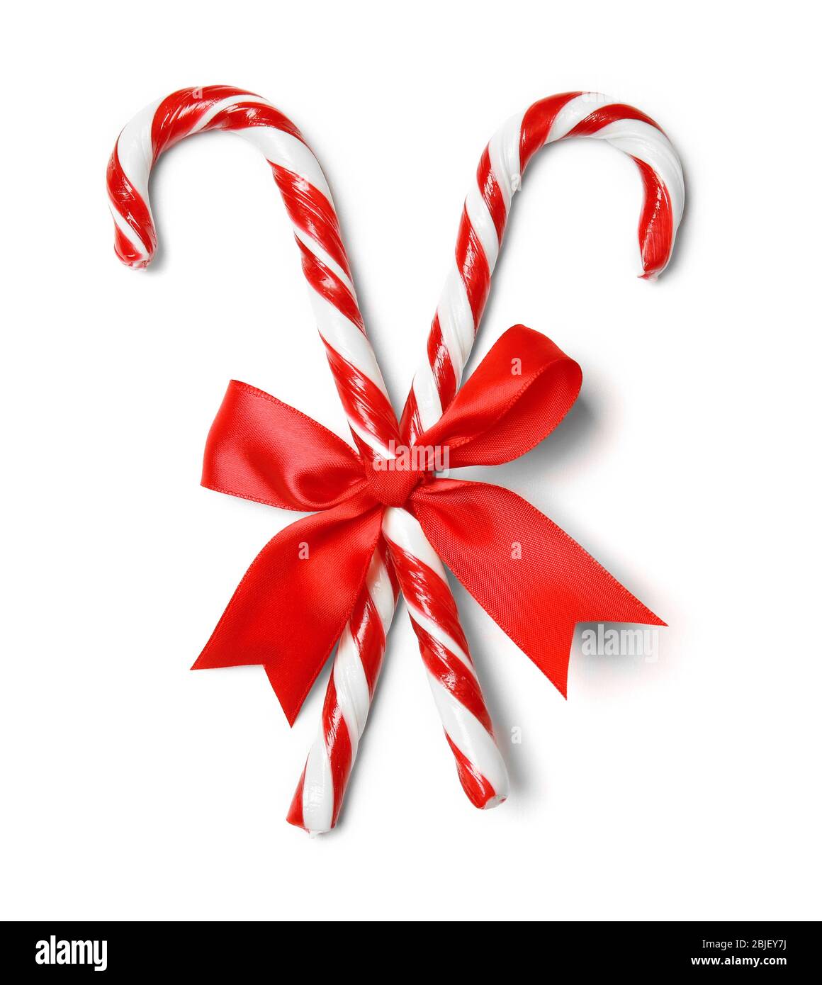 Candy canes with red bow on white background Stock Photo - Alamy